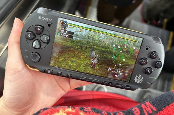 日本玩家地铁站掏出PSP玩怪猎 旁边小学生议论假货Switch
